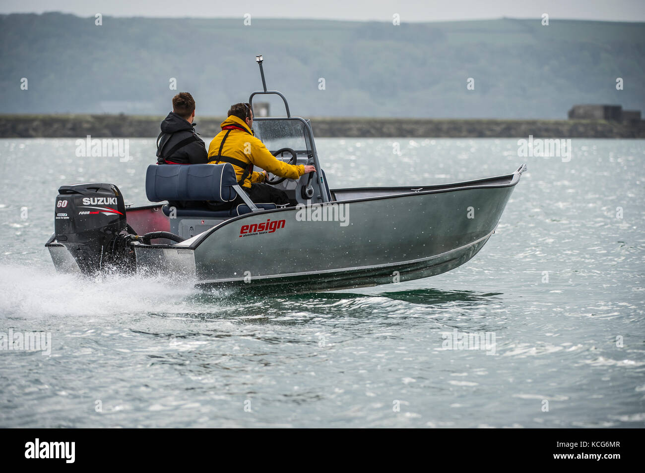 An aluminium speed boat with two male occupants on the sea off the ...