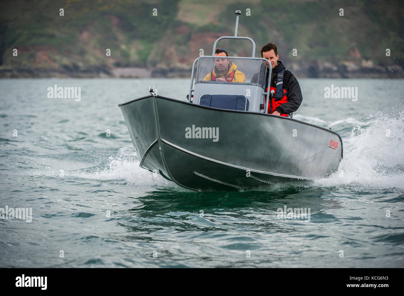 An aluminium speed boat with two male occupants on the sea off the ...