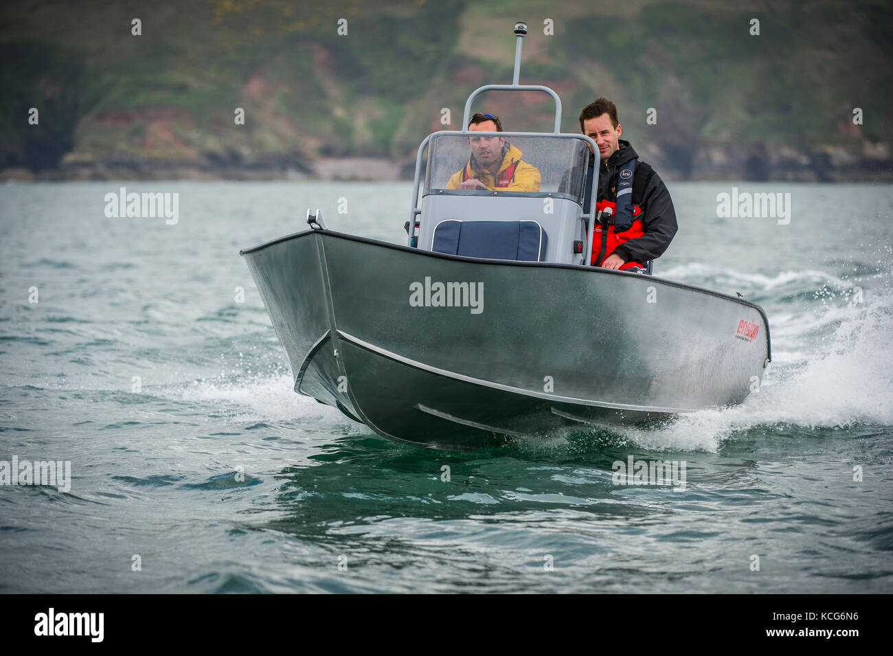 An aluminium speed boat with two male occupants on the sea off the ...