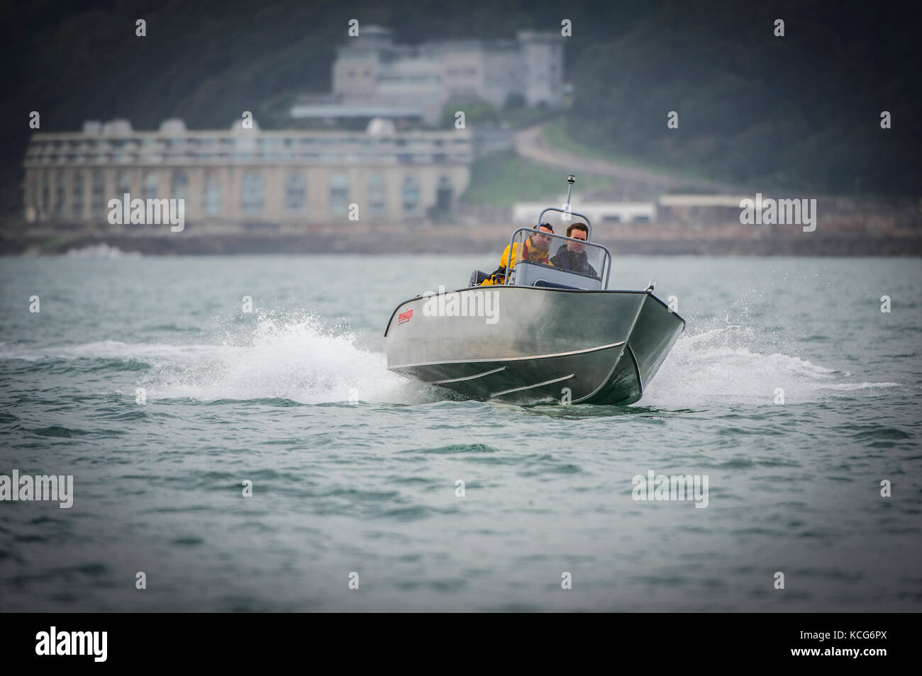 An aluminium speed boat with two male occupants on the sea off the ...
