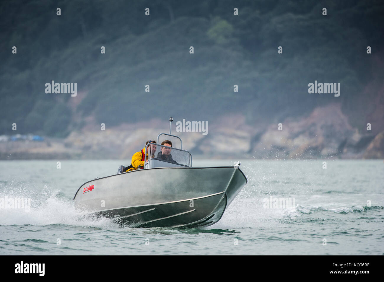 An aluminium speed boat with two male occupants on the sea off the ...