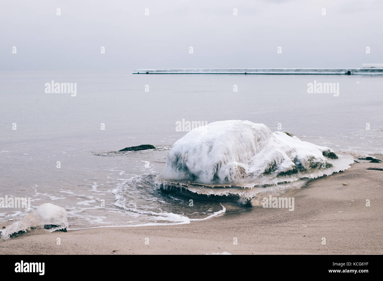 Frozen stone on the beach in winter Stock Photo - Alamy