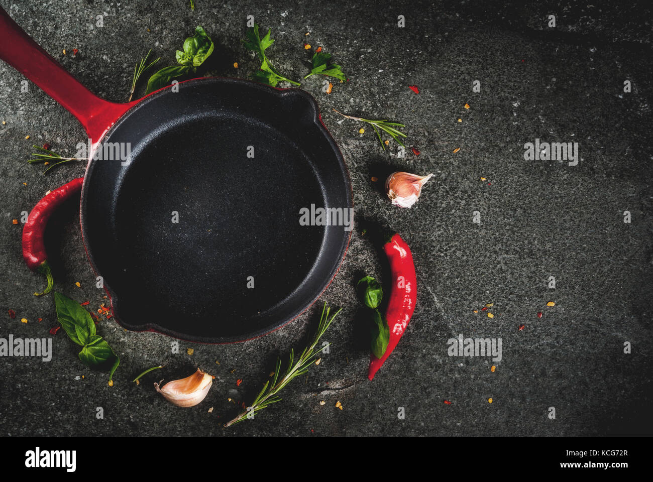 Cooking background with skillet and spices - hot pepper, garlic, basil ...