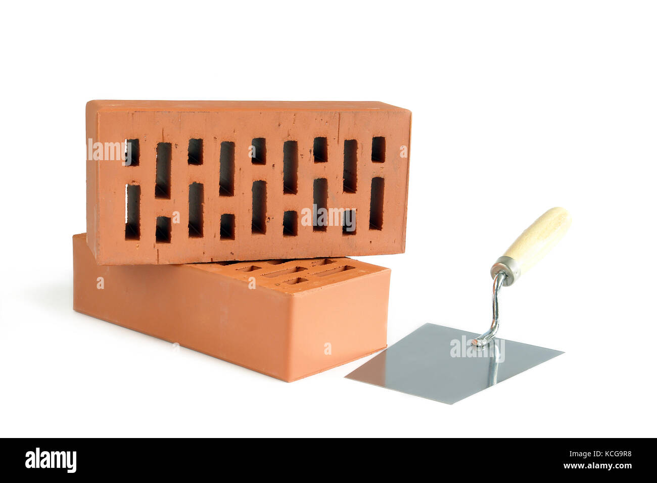 Two perforated bricks and stainless steel trowel isolated on white ...