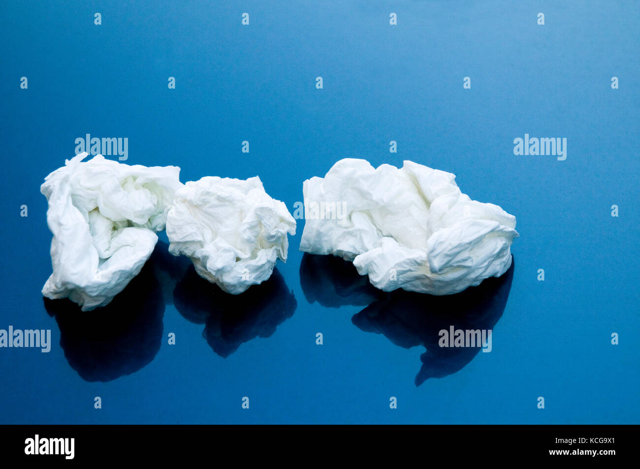 Three wads of paper on blue background Stock Photo - Alamy