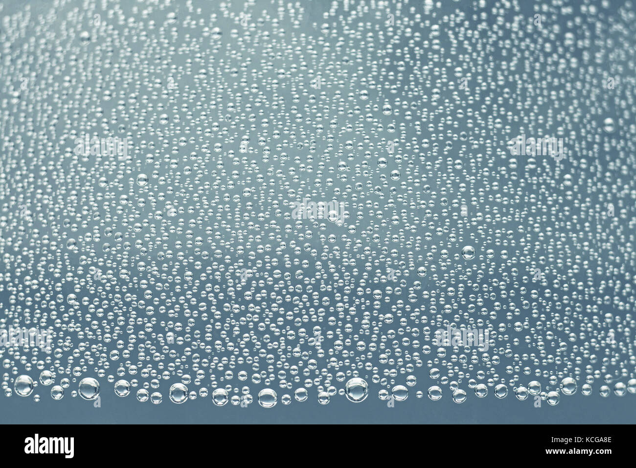 Small droplets on a window closeup. Light blue color and soft out of ...