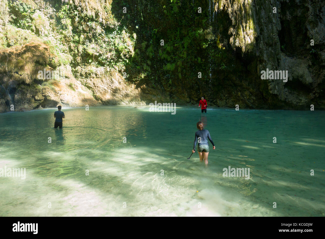 Tourists wading in a pool of water beneath a waterfall, Cebu ...