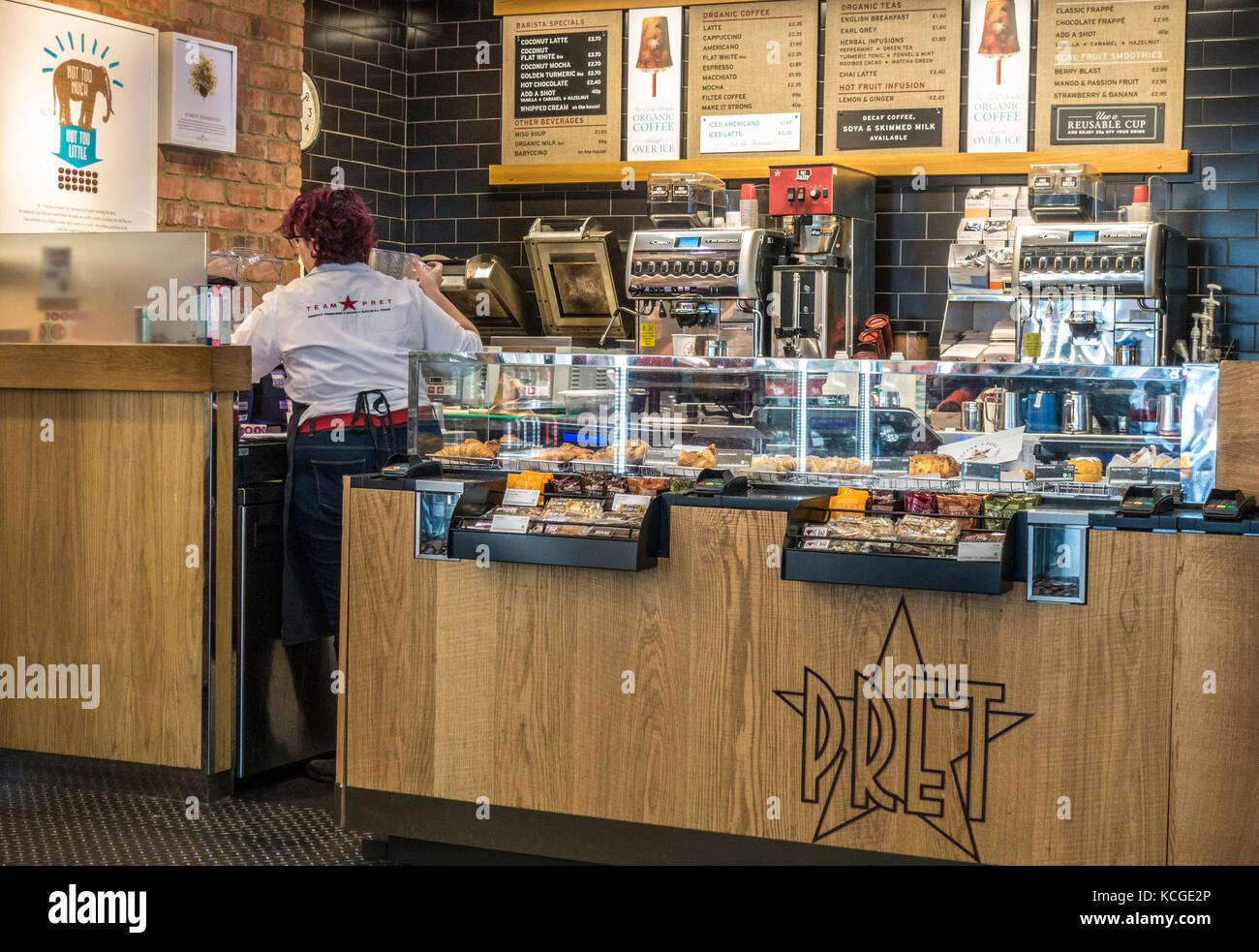 A female employee working behind the counter, with no customers around ...