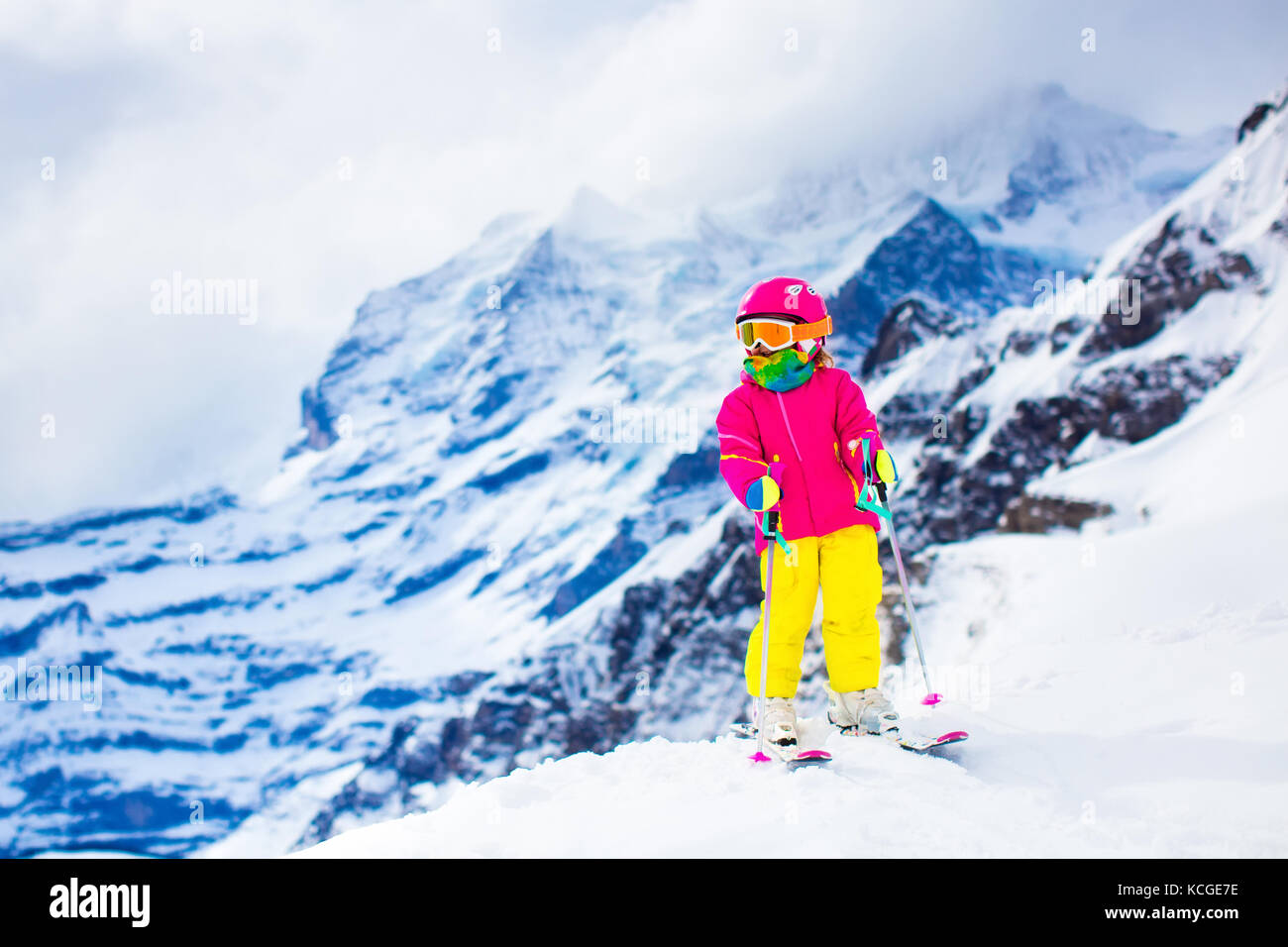 Child skiing in mountains. Active toddler kid with safety helmet ...
