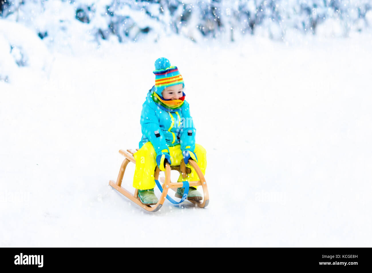 Little girl enjoying a sleigh ride. Child sledding. Toddler kid riding ...