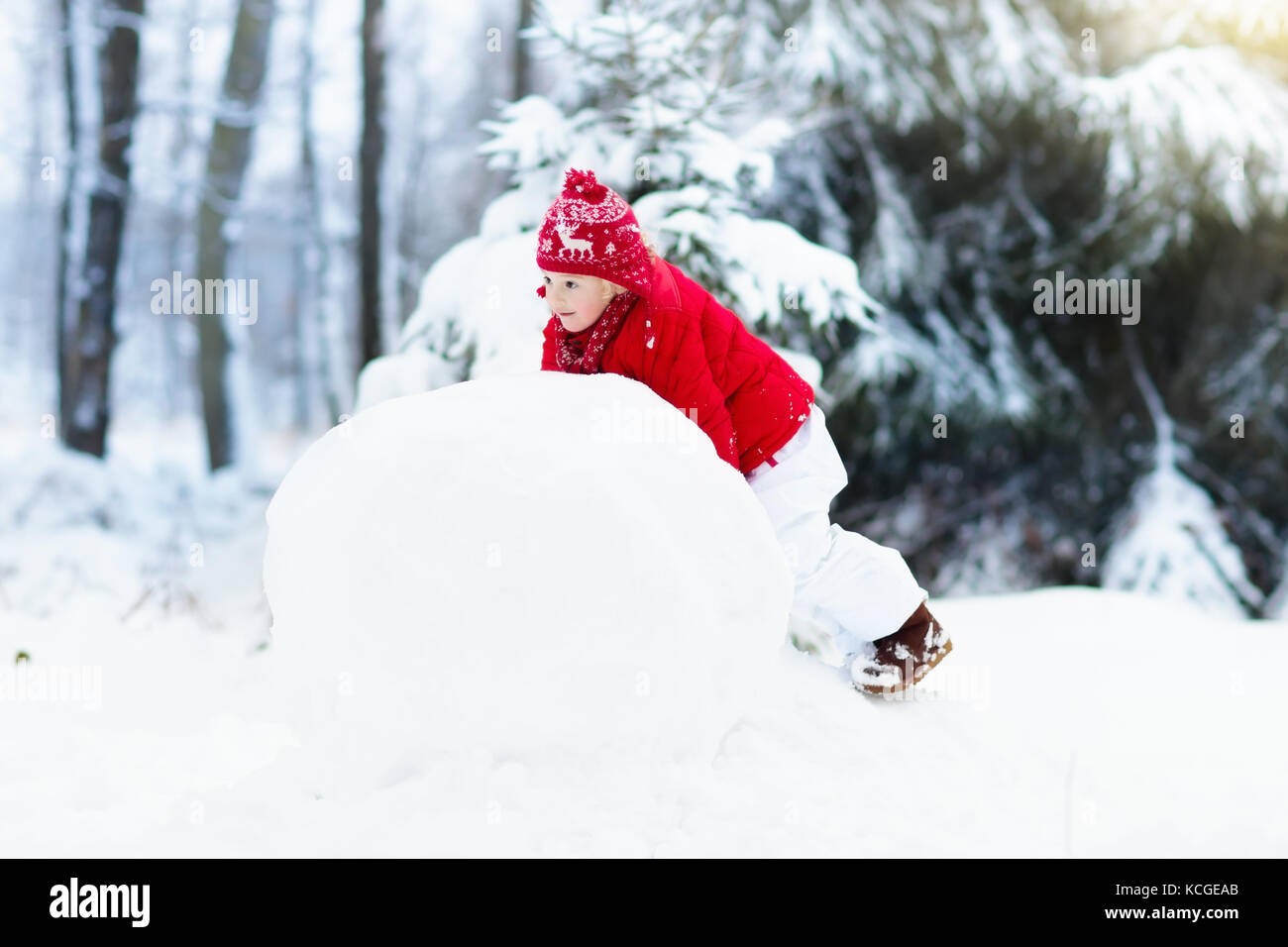 Children build snowman. Kids building snow man playing outdoors on ...