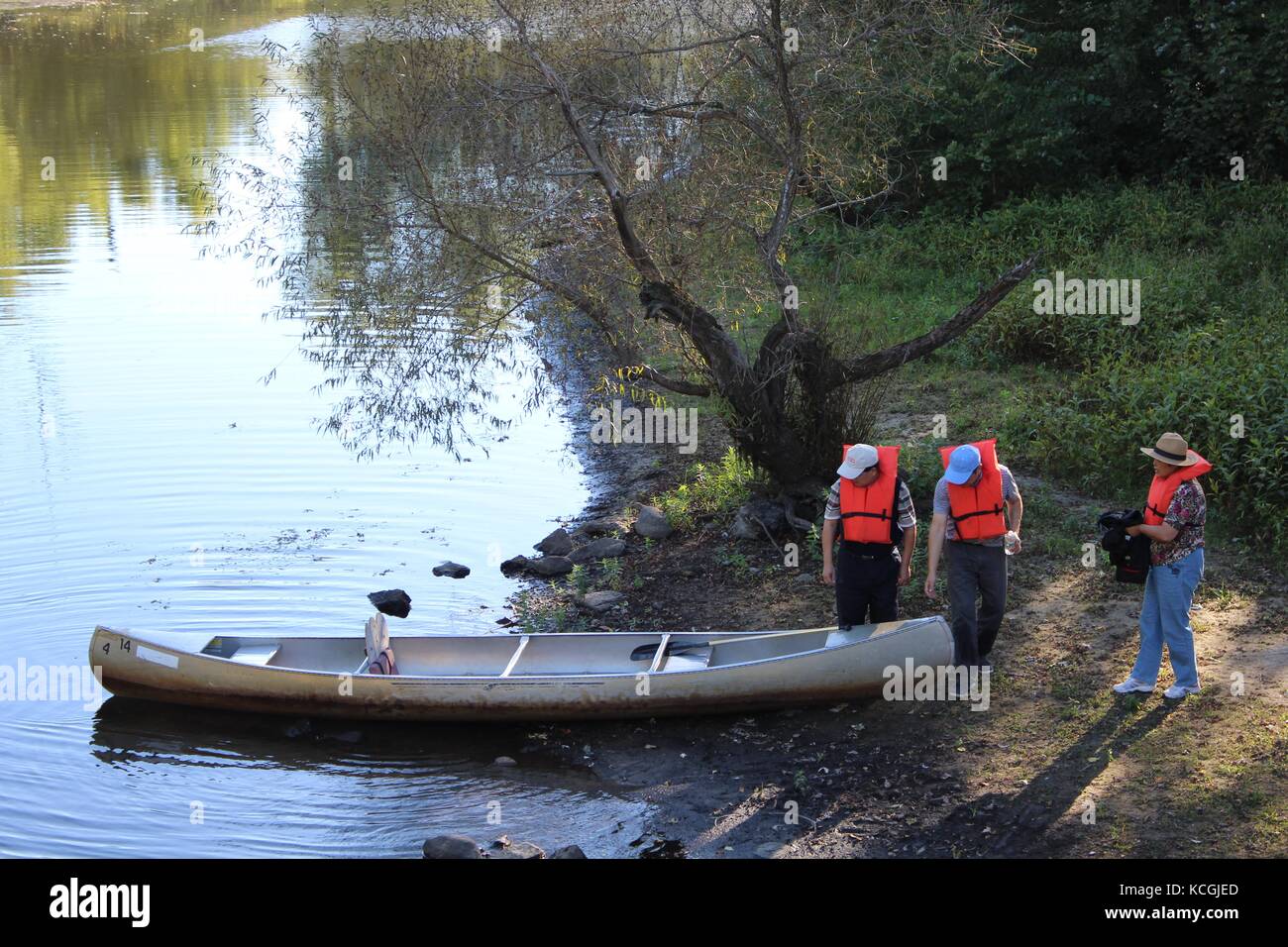 People getting ready to go for a canoe paddle down a lazy river in a ...