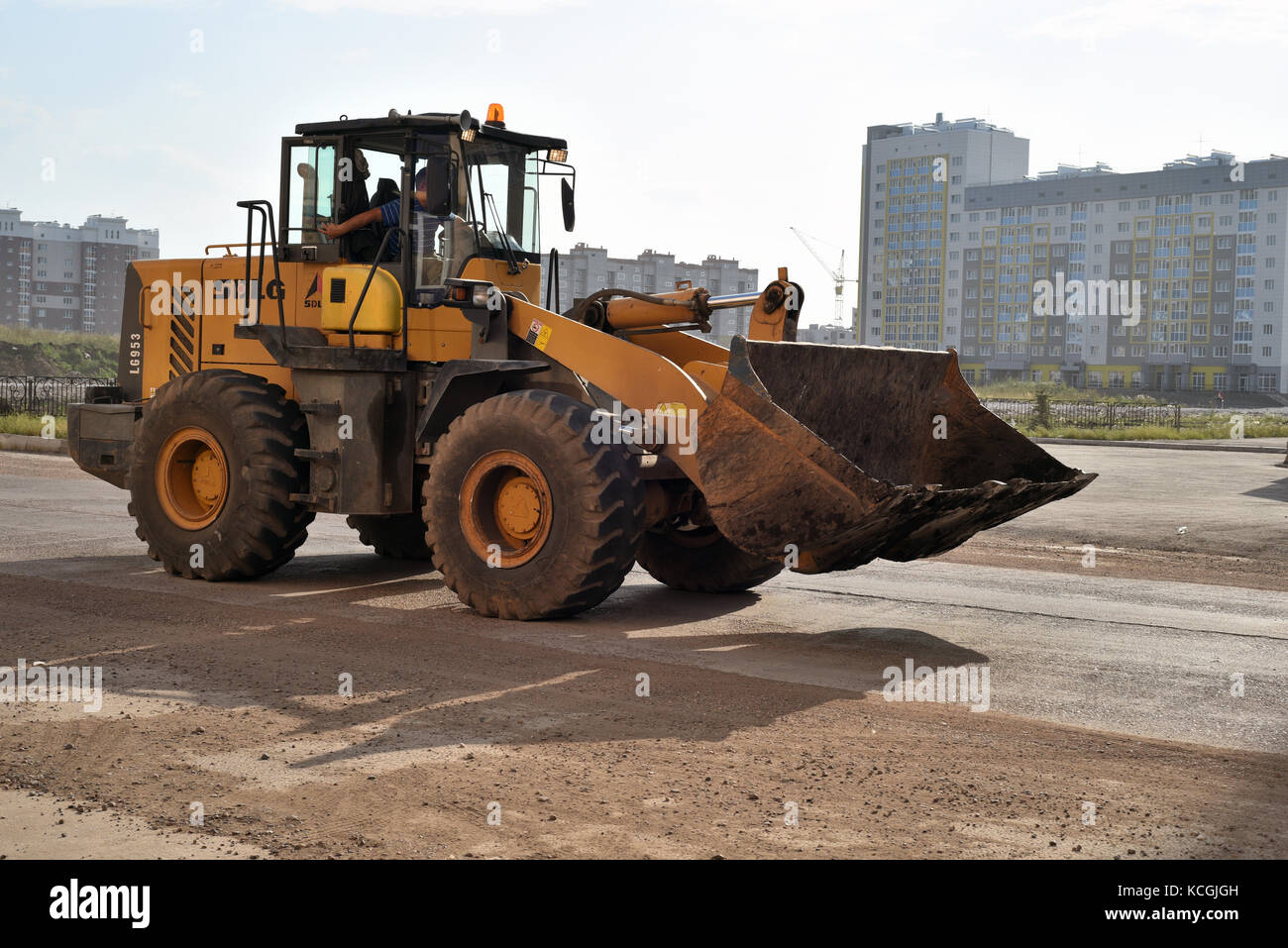 Modern SDLG LG953 earthmover machine in dirt stained yellow travels ...