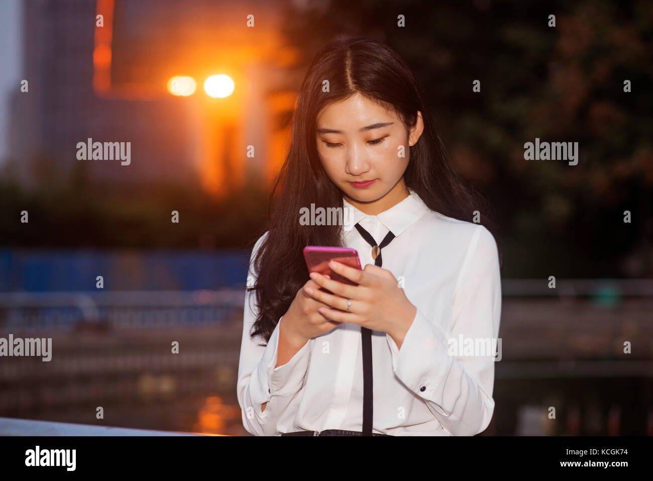 The young woman use a mobile phone at night Stock Photo - Alamy
