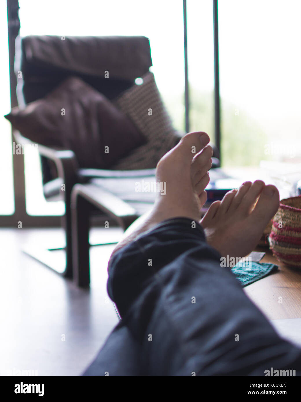 person relaxing with feet up. bare feet and wearing jeans Stock Photo ...