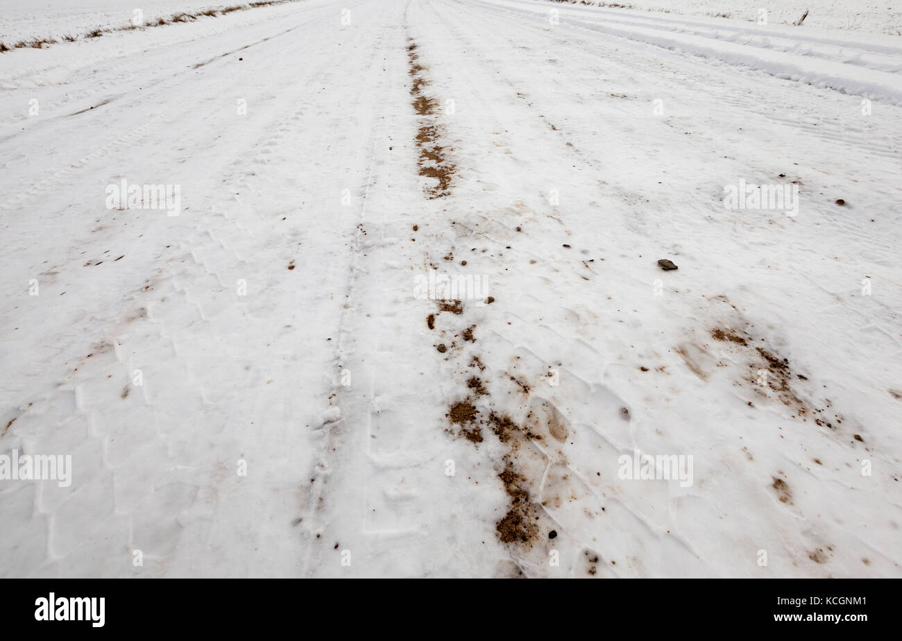 ruts on the road from cars. The territory is covered with snow in the ...