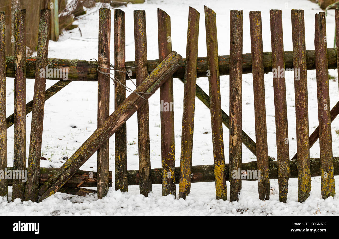 an old destroyed wooden fence in the countryside. Part of the fence is ...
