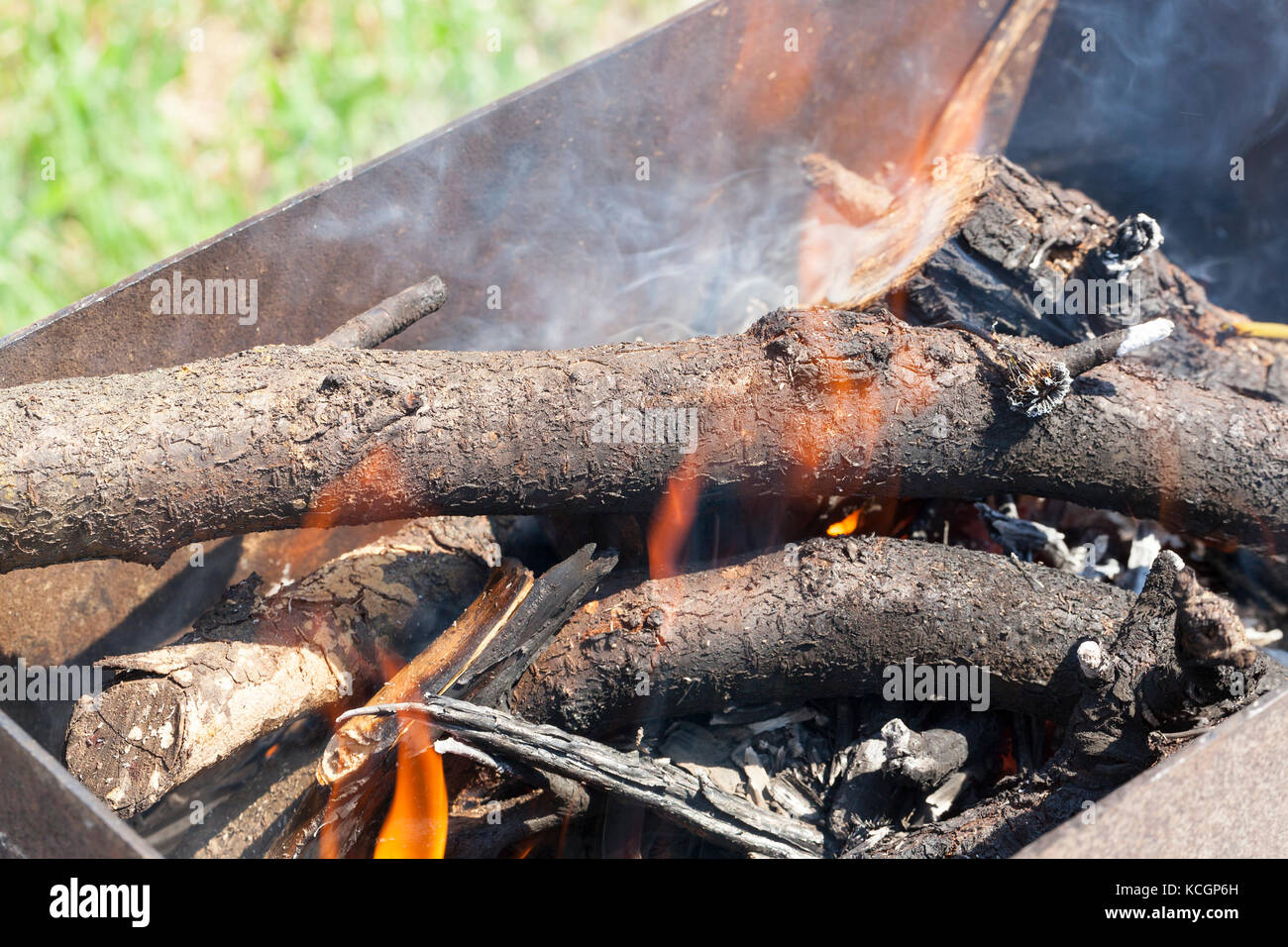 Burning logs in the barbecue before cooking meat dishes. Rest in the ...