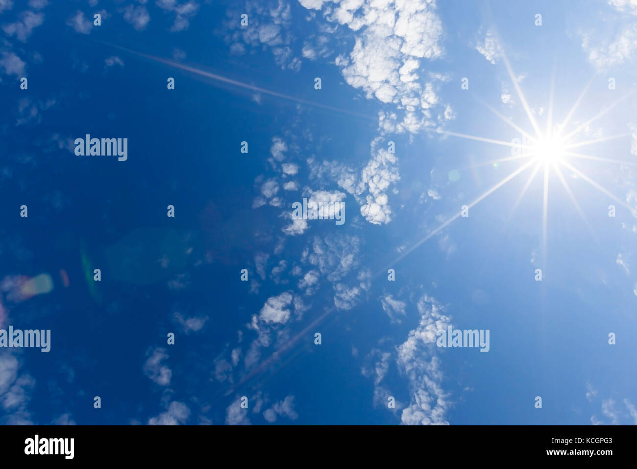 A bright sun with white rays departing from it. In the blue sky there ...