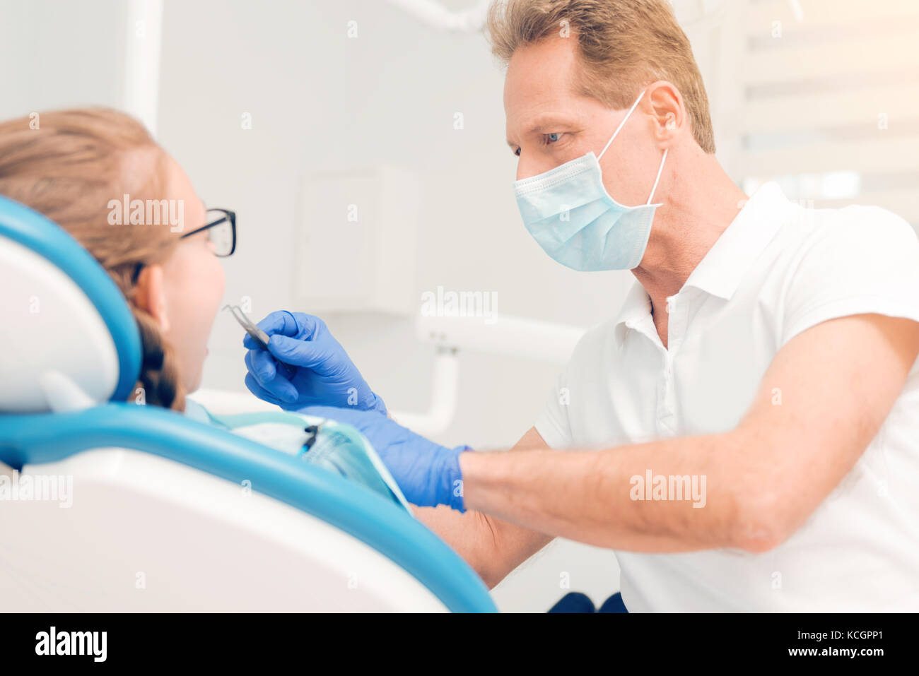 Serious dental professional treating teeth of child Stock Photo - Alamy