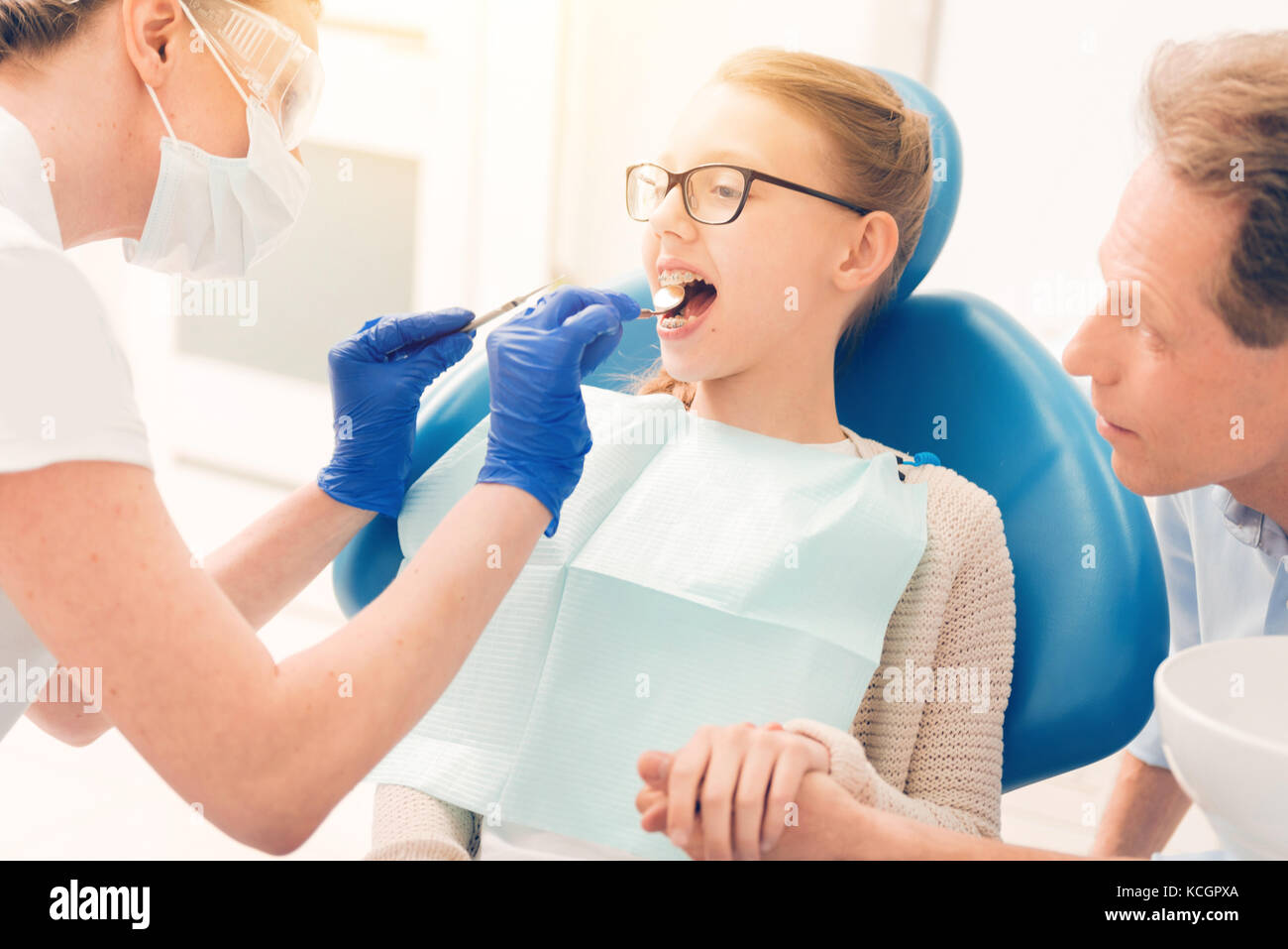 Mindful father supporting her daughter during dental checkup Stock Photo - Alamy