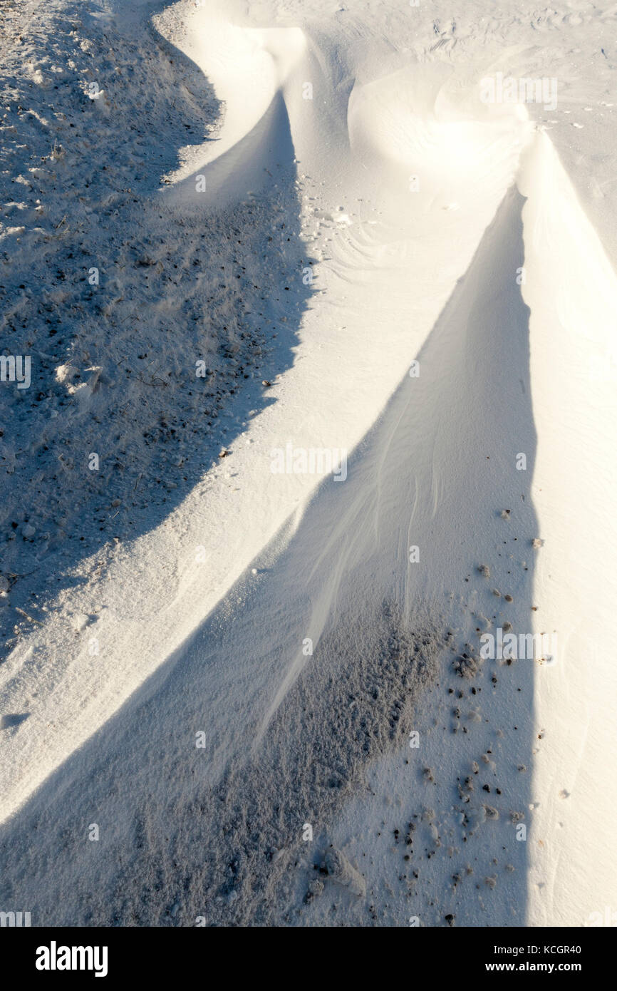 snow drifts lying near the road. On the surface you can see dirt from ...