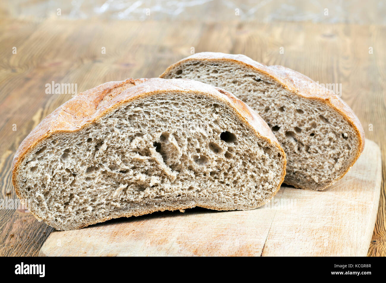 Cut into two halves of a light-colored loaf baked from wheat flour ...
