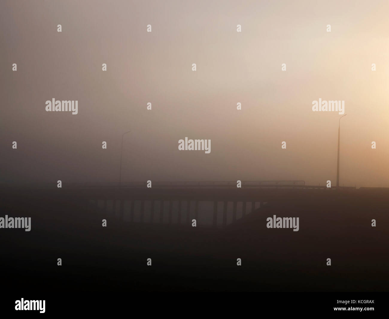 Dense fog covering the view of the bridge at the road junction. visible ...