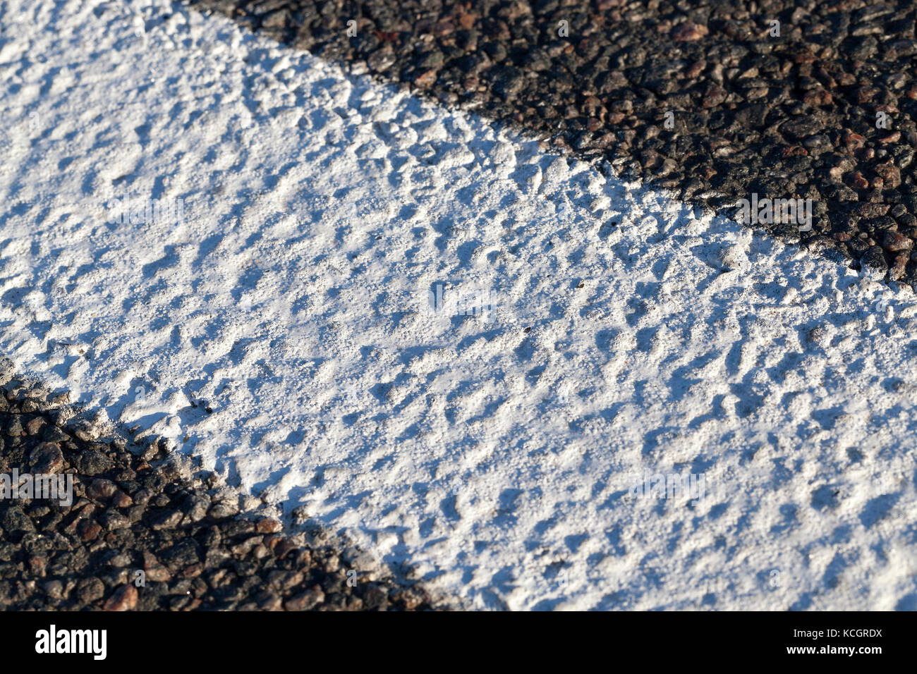 The texture of the road asphalt, which is marked with a white line of ...
