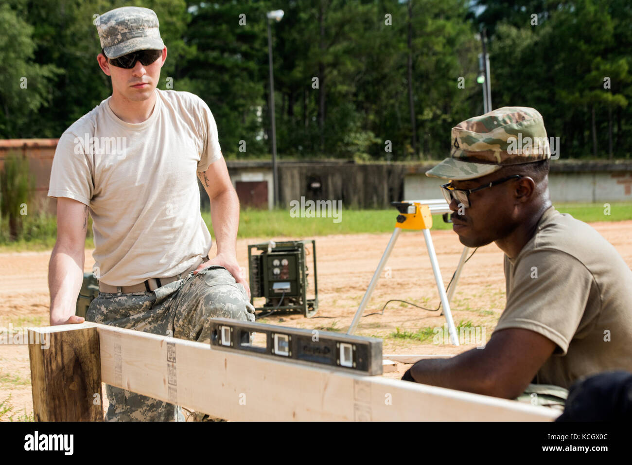 Soldiers use a level while constructing a flooring system as part of ...