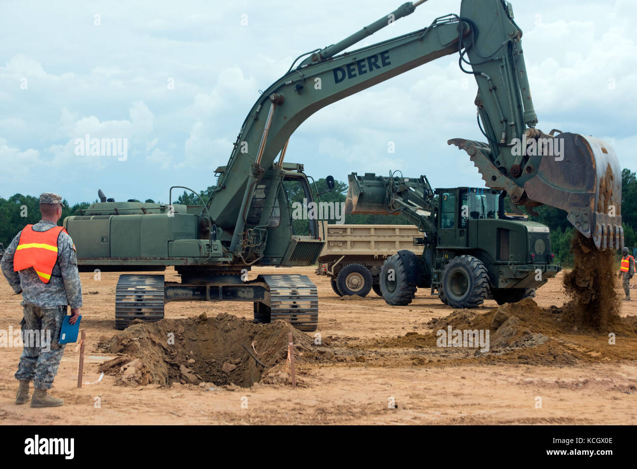 U.S. Army Sgt. Jim Miller operates a heavy equipment excavator to dig a ...