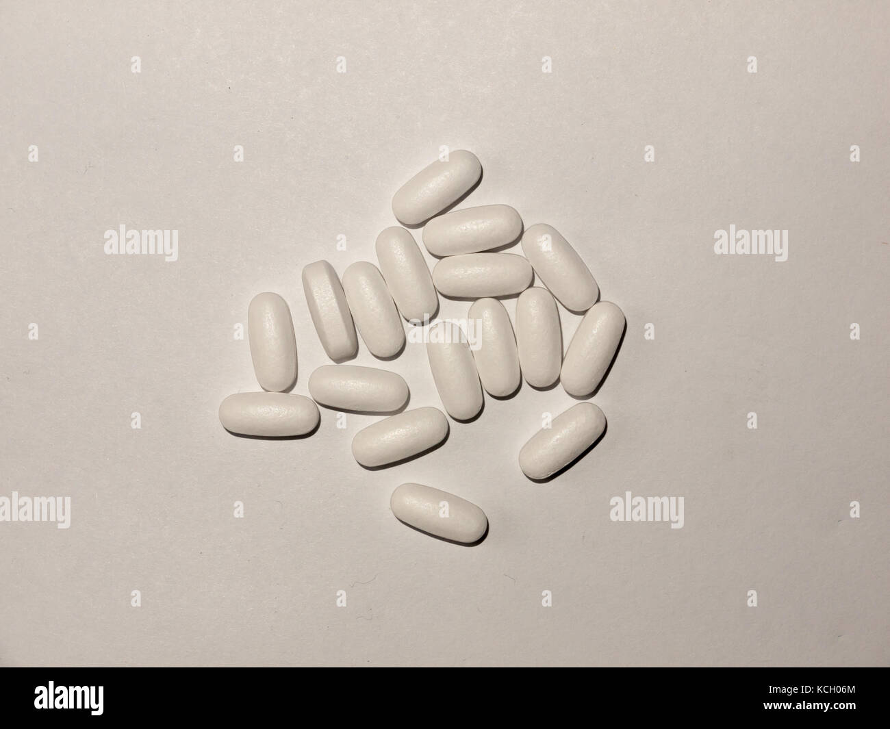 many white generic tablet pills on a white background; Essex; England ...