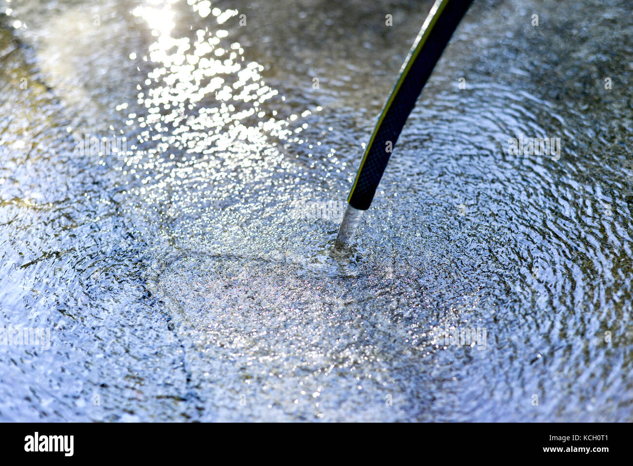 cleaning the cement floor with water from hose, image of a Stock Photo ...