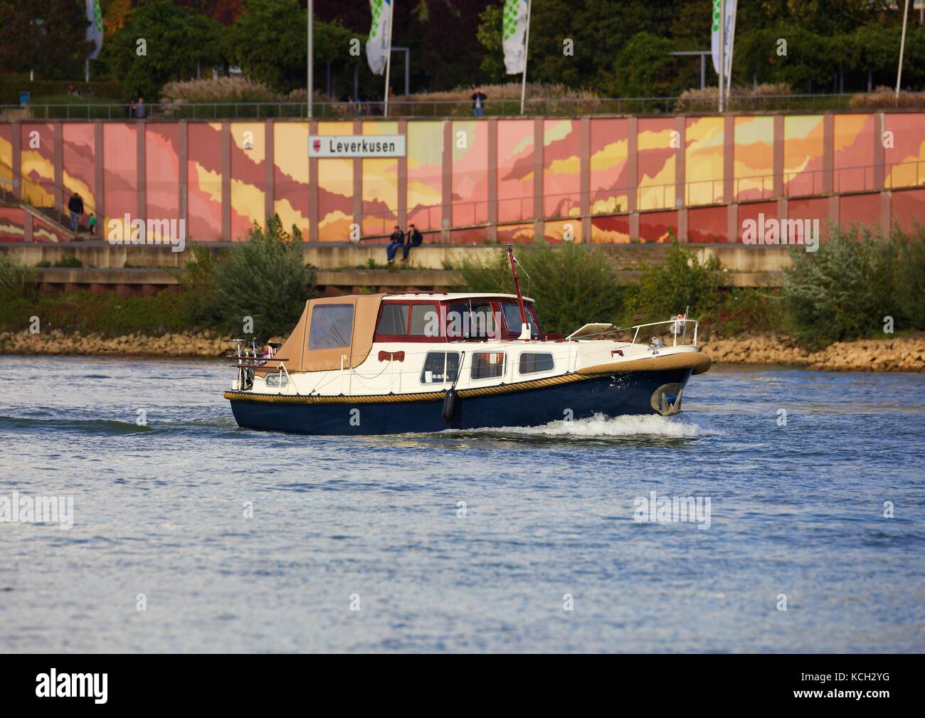 Small yacht on river Rhine in front of Leverkusen sign Stock Photo - Alamy