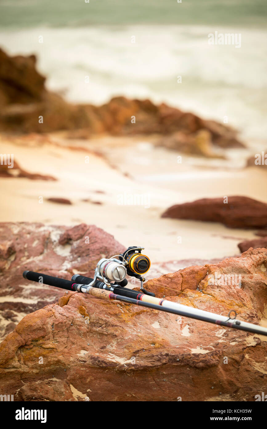 Fishing rods for surf fishing sitting on rocks at the beach Stock Photo ...