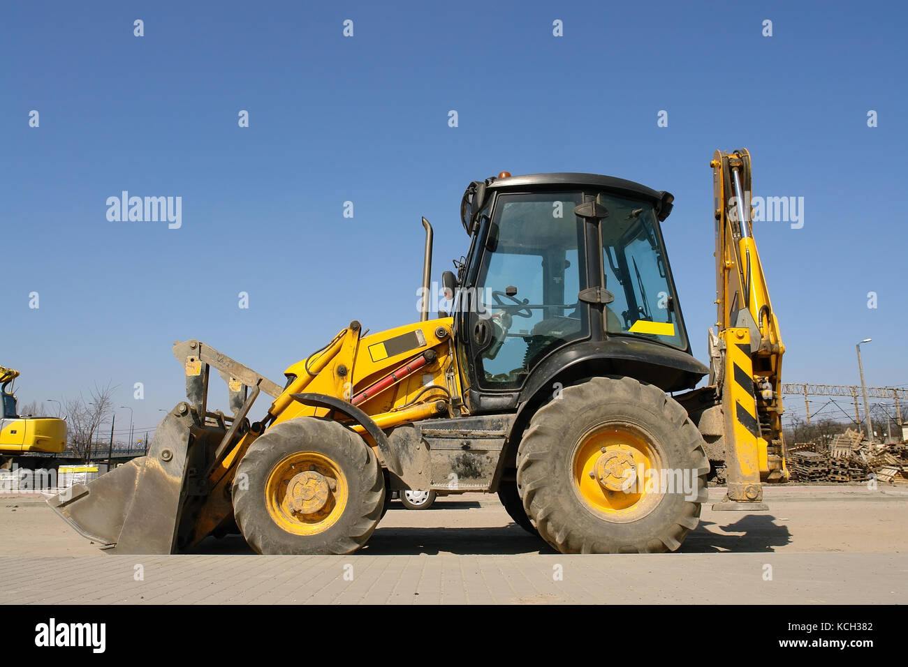 Yellow backhoe loader on construction site- side view Stock Photo - Alamy