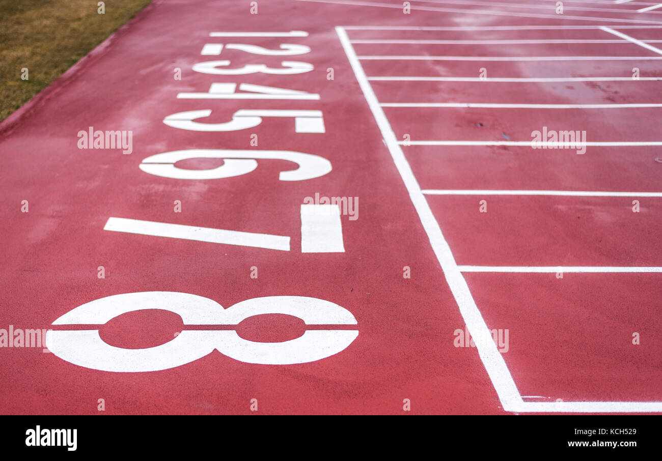 The starting line on a red running track with the lane numbers from ...