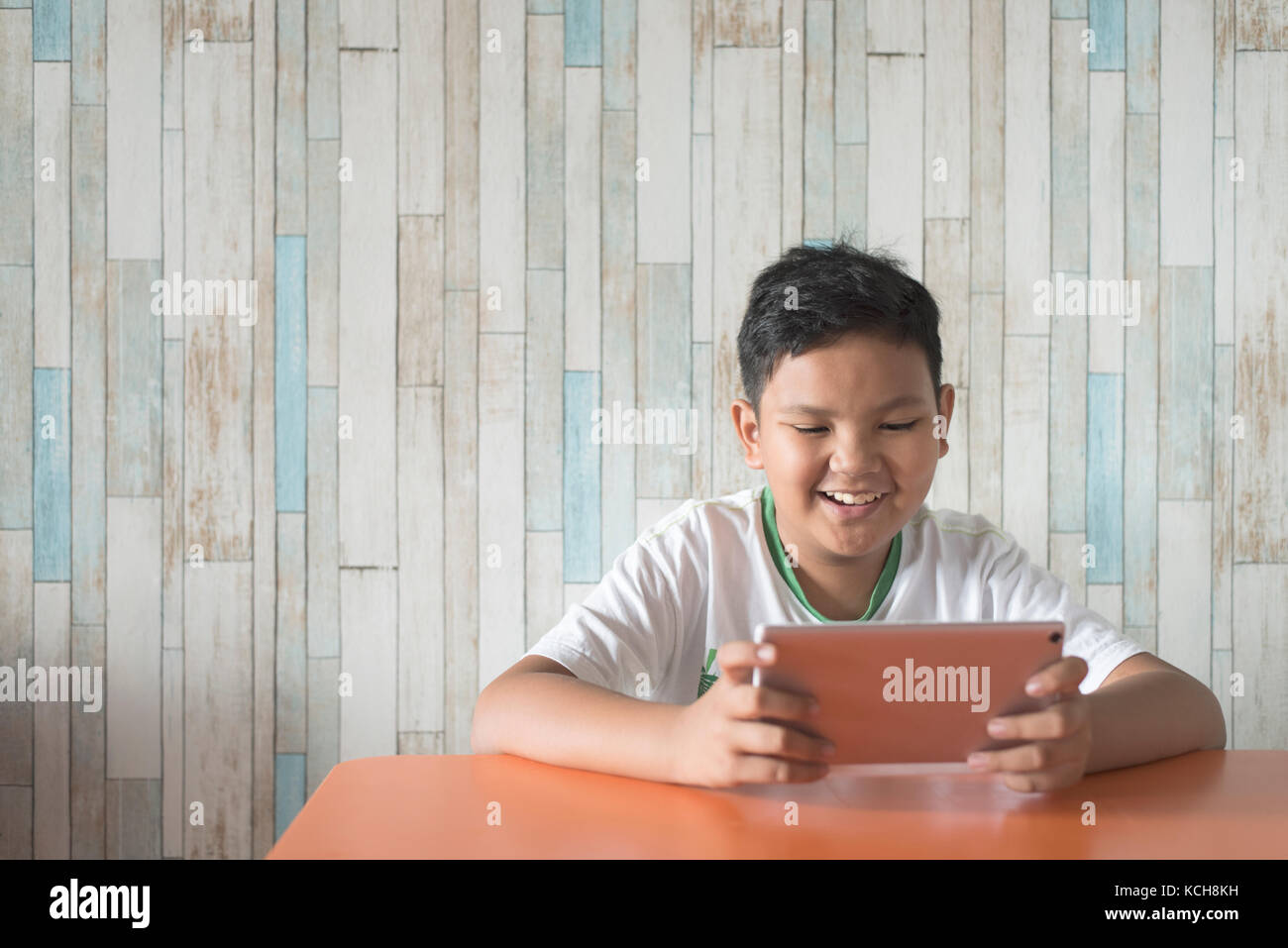 young asian boy using digital tablet at the dining table at home. young ...