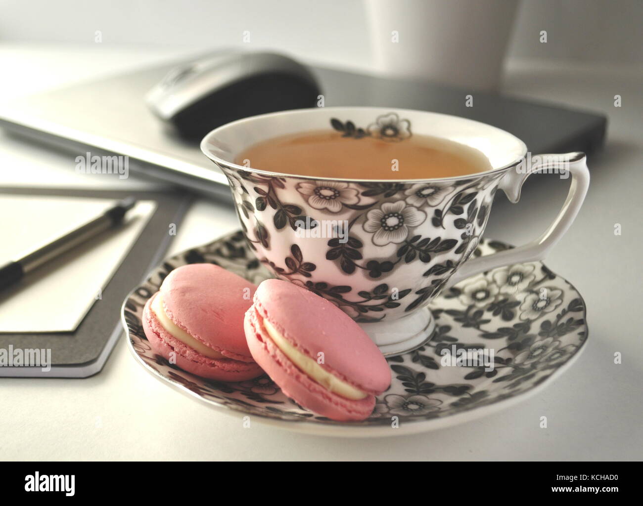 Cup of tea with French macaroons, laptop computer, mouse, pen and ...