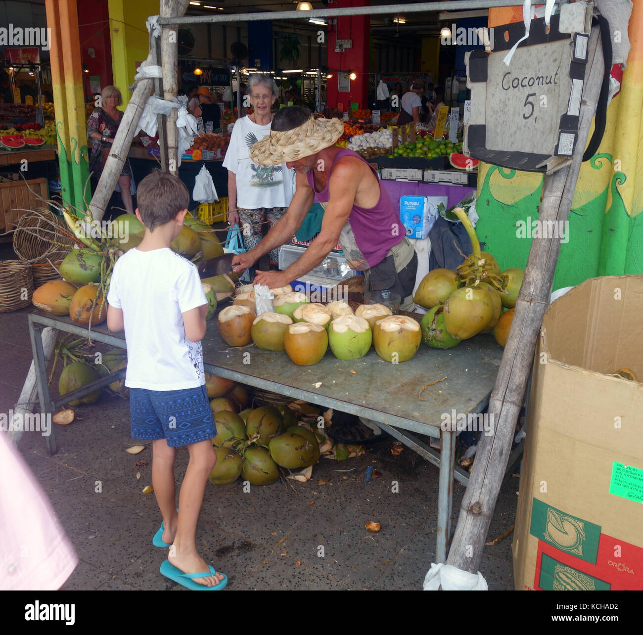 Boy buying a fresh coconut to drink, Rustys Markets, Cairns, Queensland ...