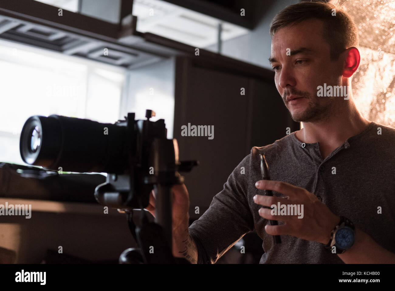 a young photographer in the Studio in front of a window Stock Photo - Alamy