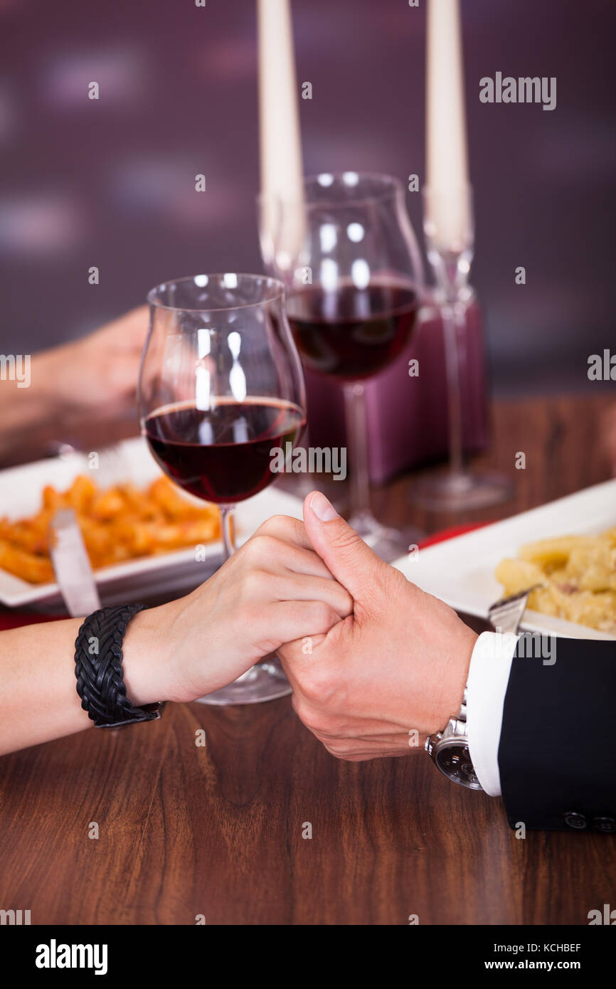 Romantic Couple Holding Each Other's Hand At Dinner In An Restaurant ...