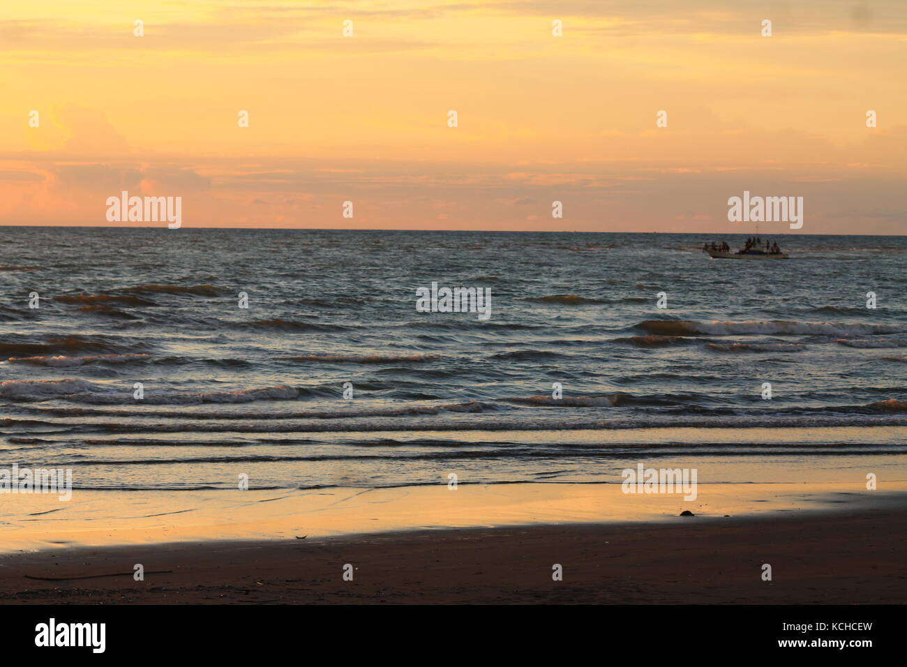 Silhoutte of a fishing boat in the vast sea on a tropical summer sunset ...