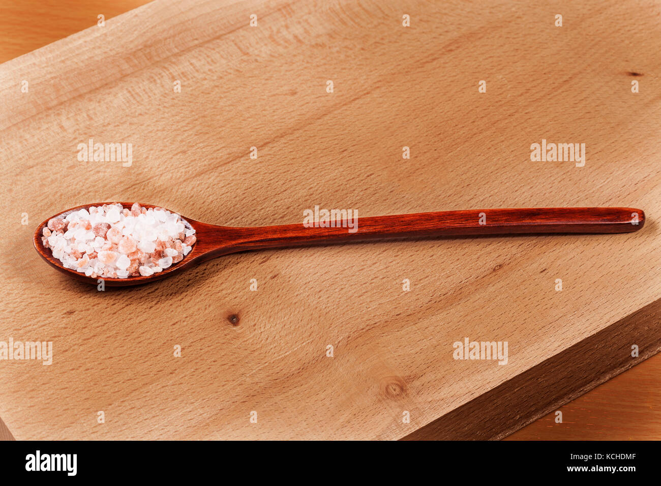 Brown Wood Spoon With Himalayan Pink Salt on Wood Cutting Board Stock ...