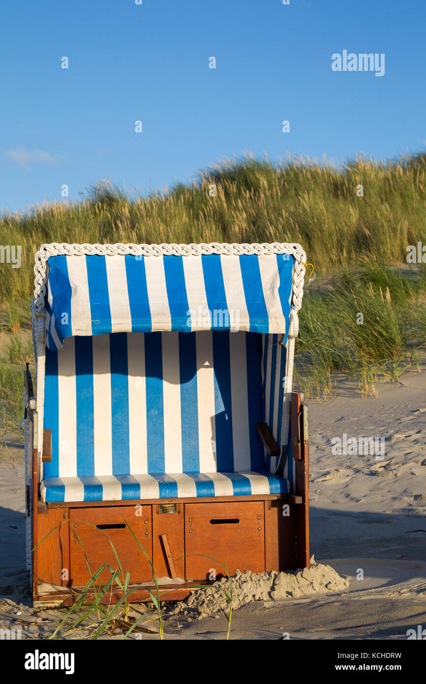 Beach chair in evening light on the beach of the north sea island Juist ...