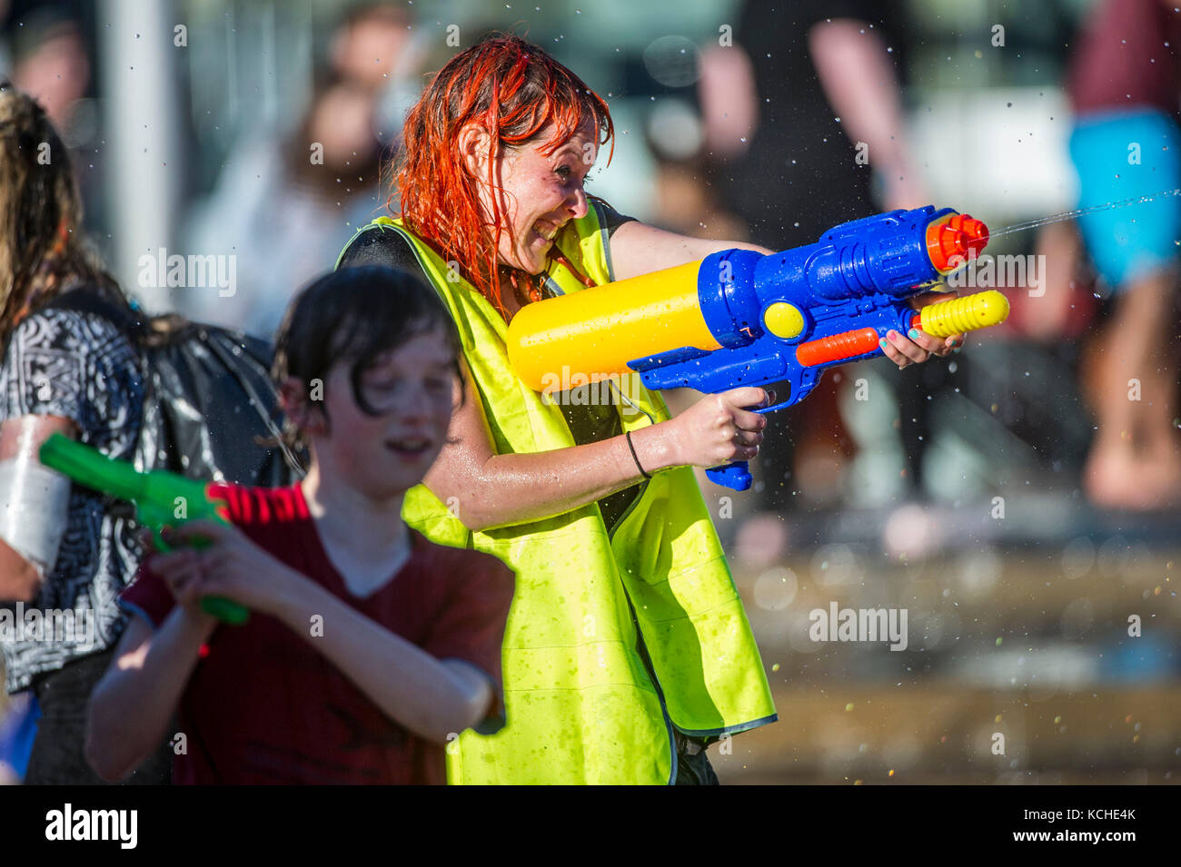 A women with a water pistol takes part in a charity water fight in ...