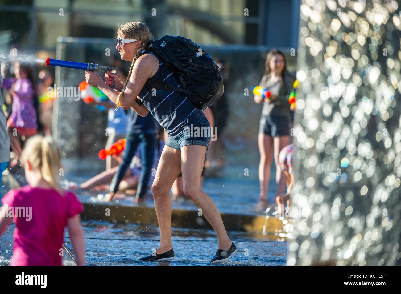A women with a water pistol takes part in a charity water fight in ...