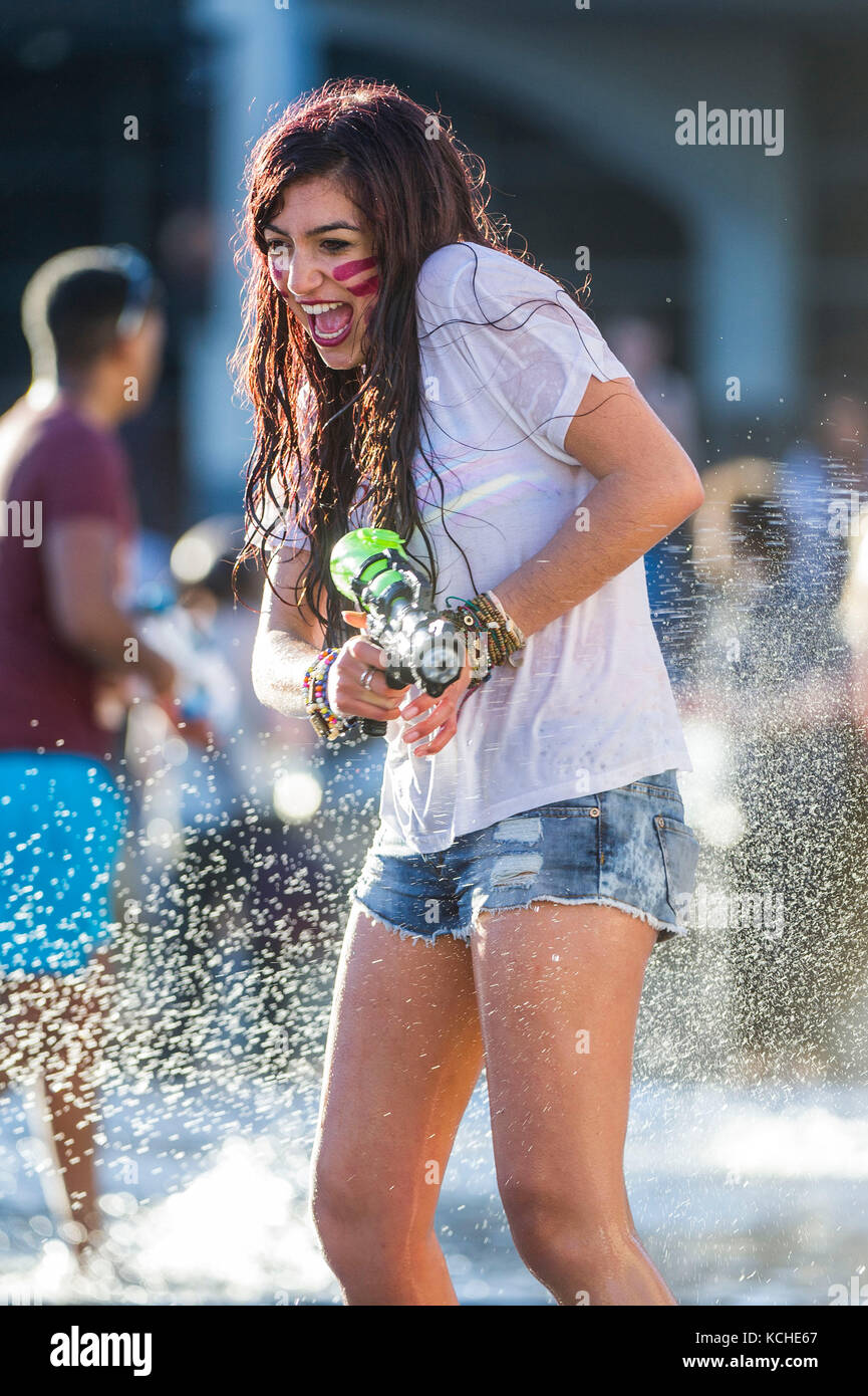 A teenage girl with a water pistol takes part in a charity water fight ...