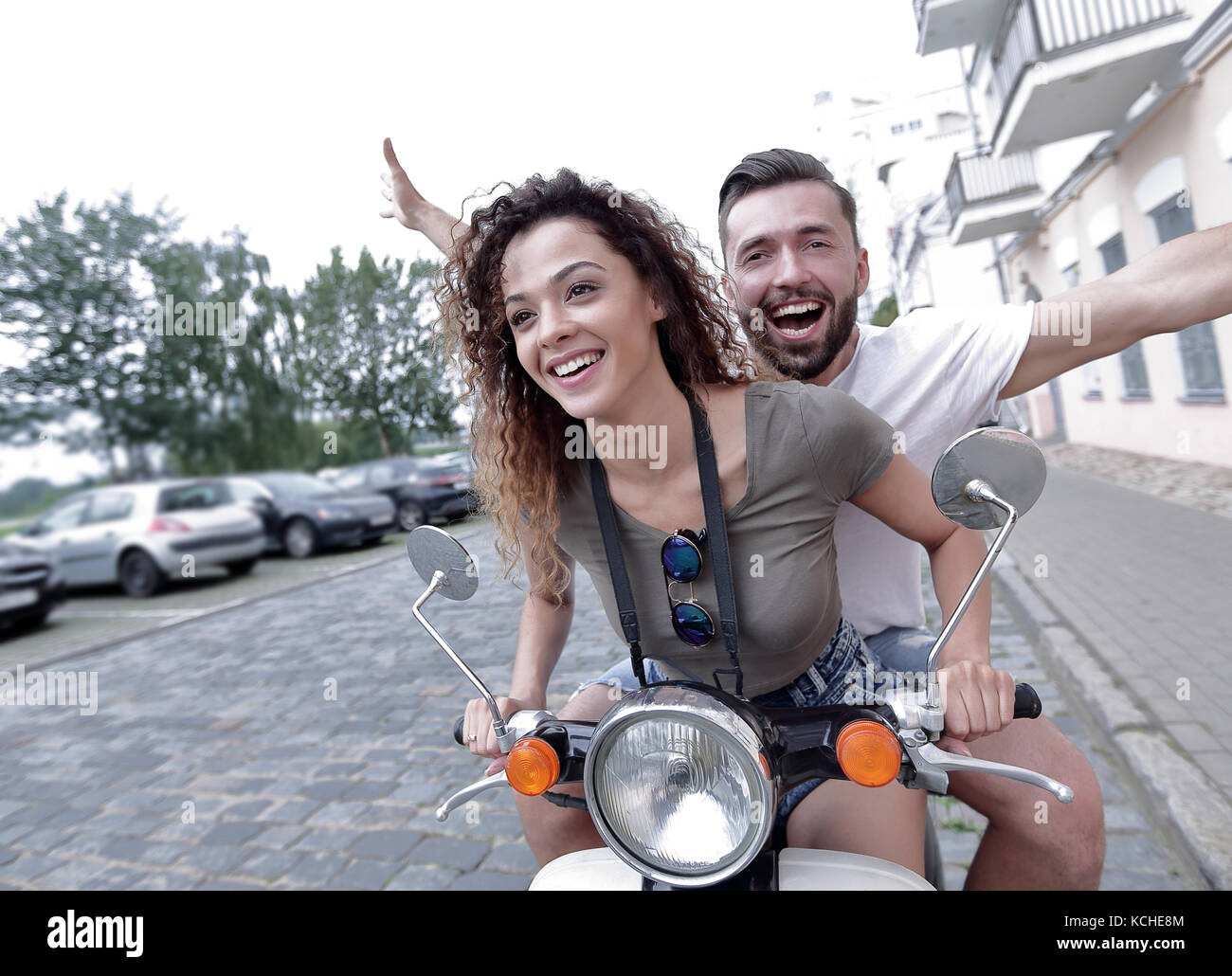 Couple riding motor scooter in old city street Stock Photo - Alamy