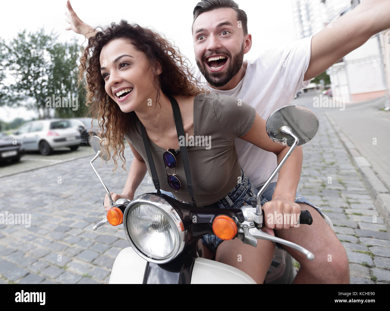 Couple riding motor scooter in old city street Stock Photo - Alamy
